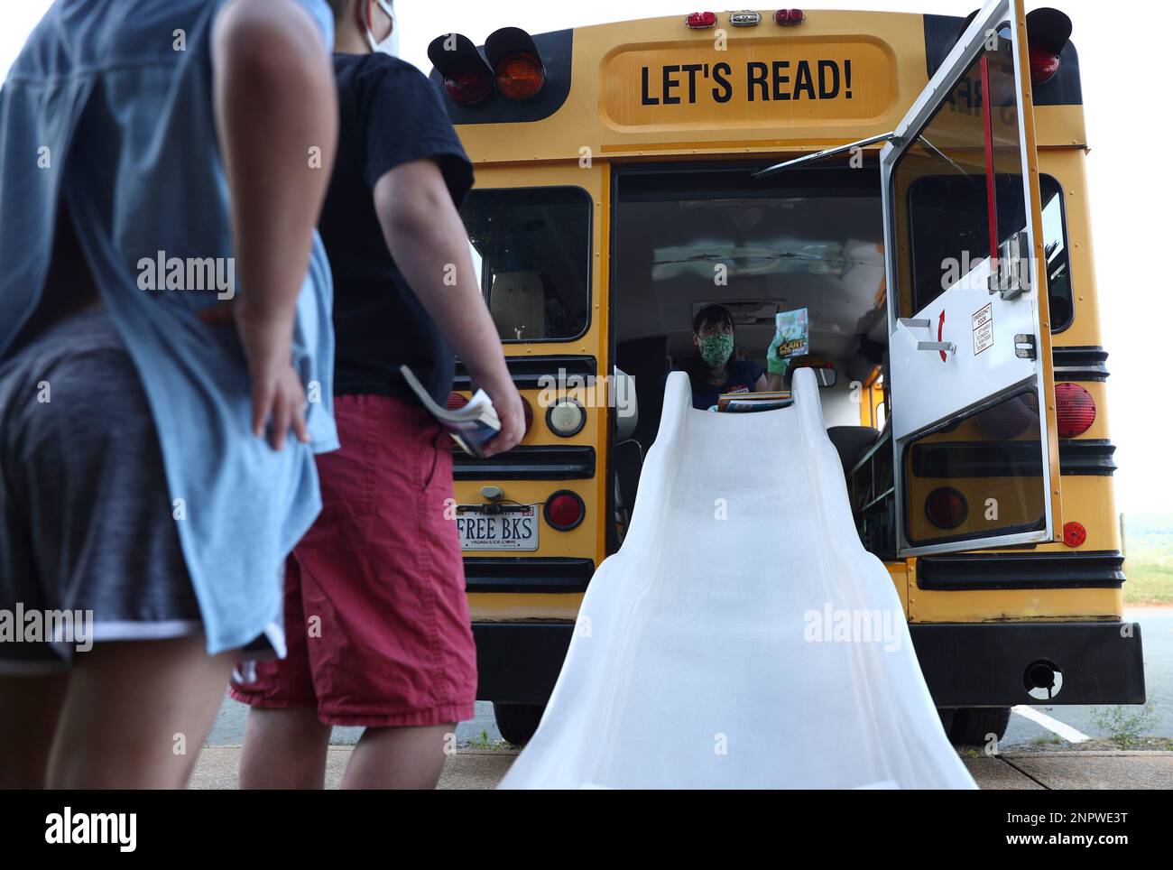 The Free Book Bus founder Sharon Stone holds up books for kids Friday ...