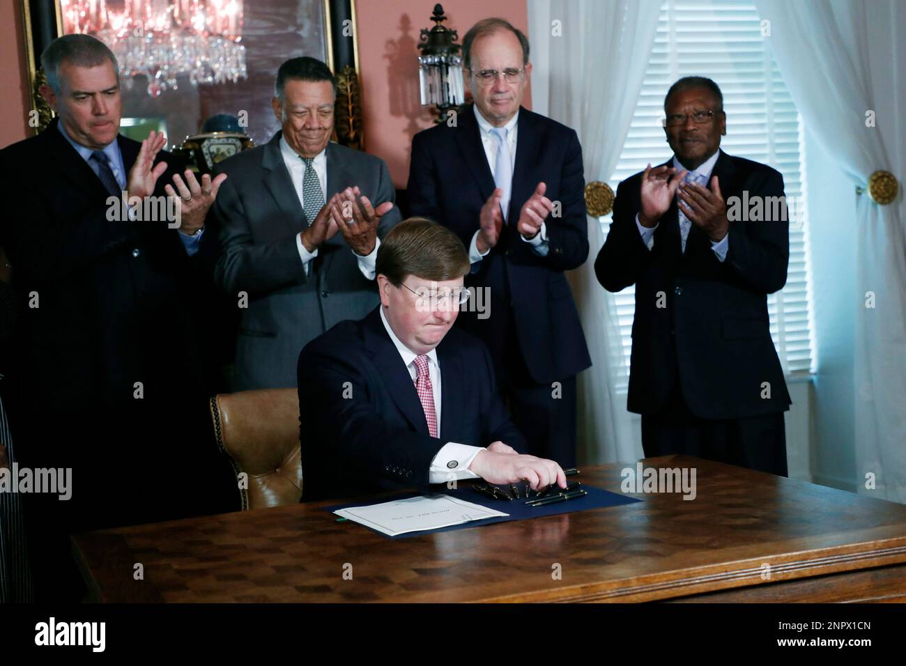 Mississippi Republican Gov. Tate Reeves completes signing the bill that ...