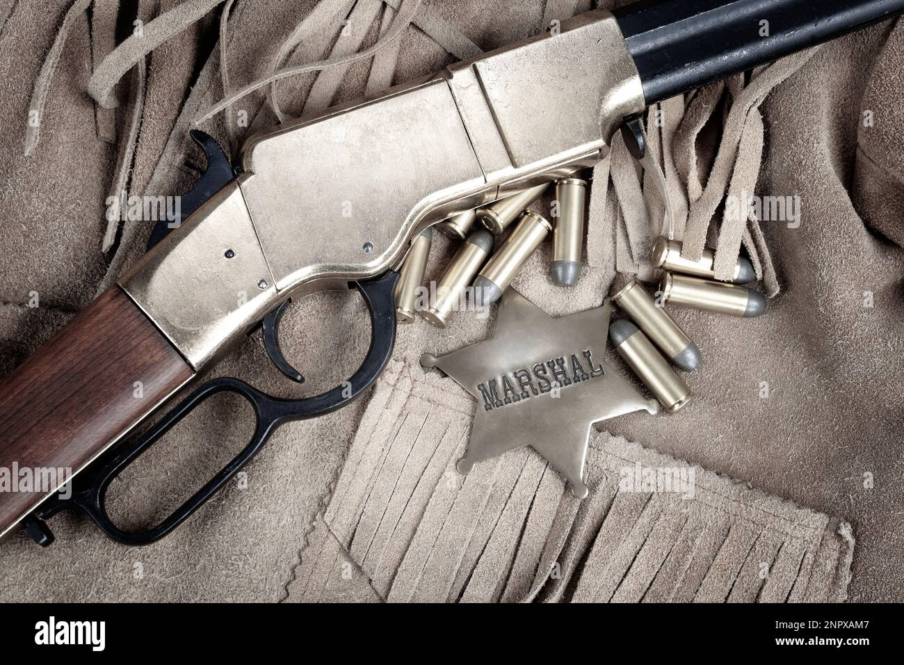 Old west period repeating rifle with ammunition and marshal badge on ...