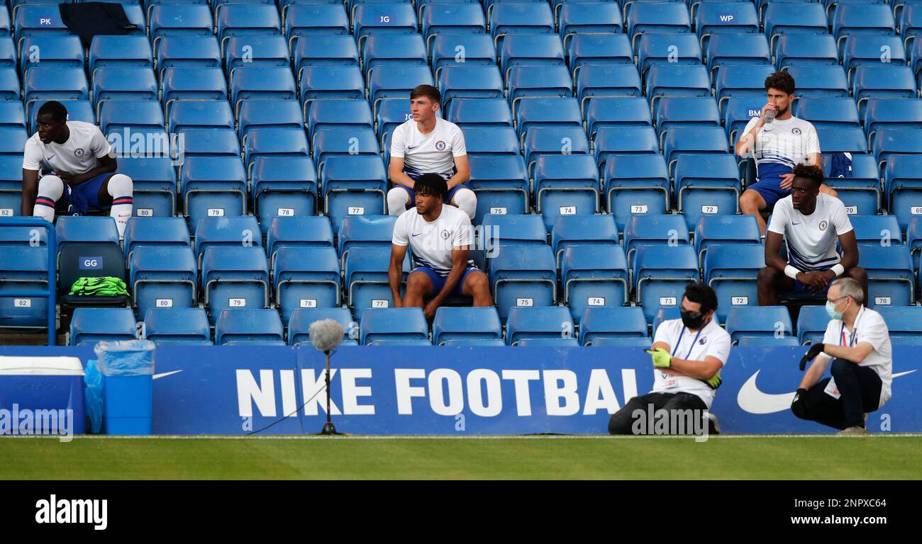 Chelsea players sit apart on the bench ahead of the English Premier ...