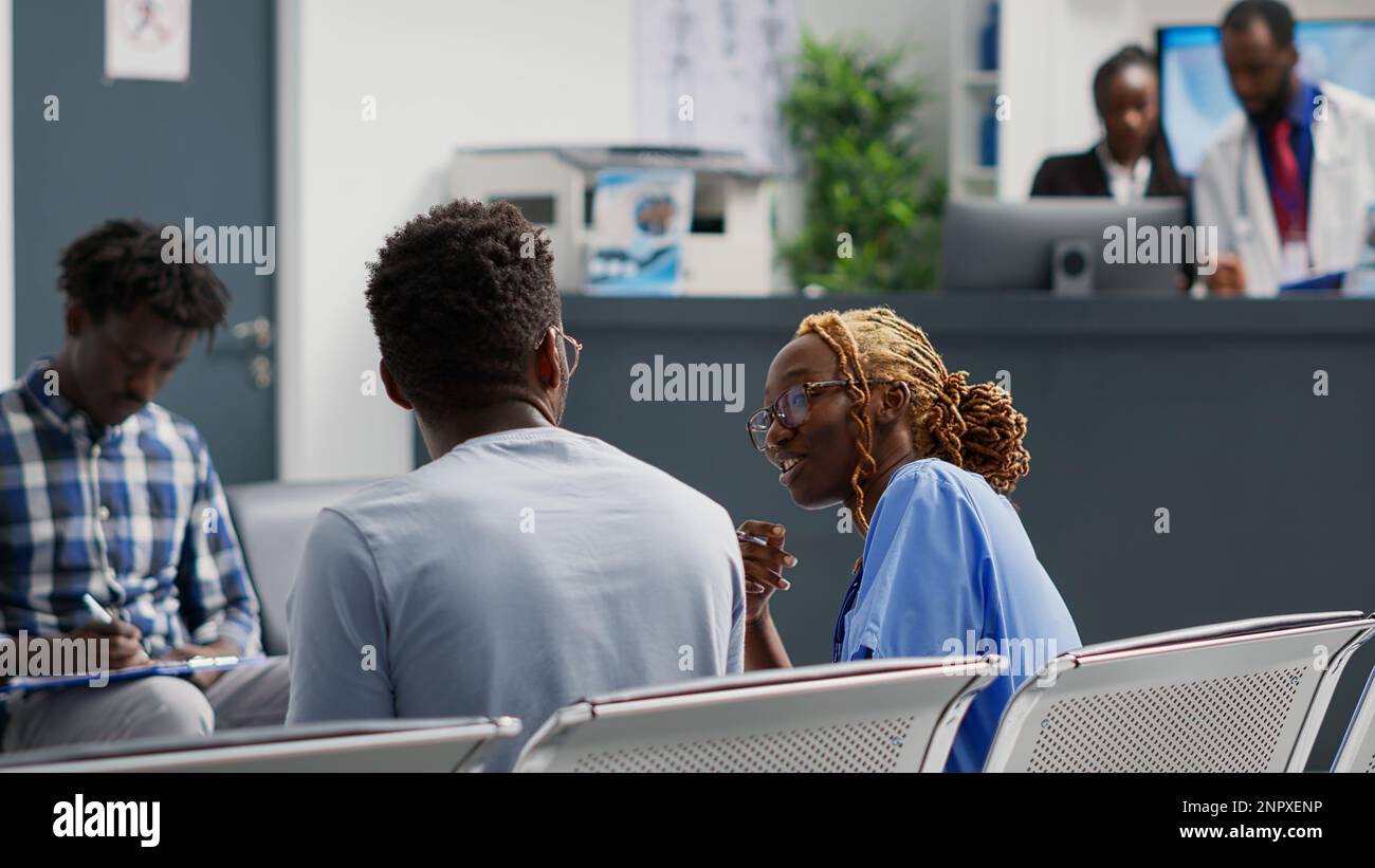 Medical assistant having conversation with patient in waiting area ...