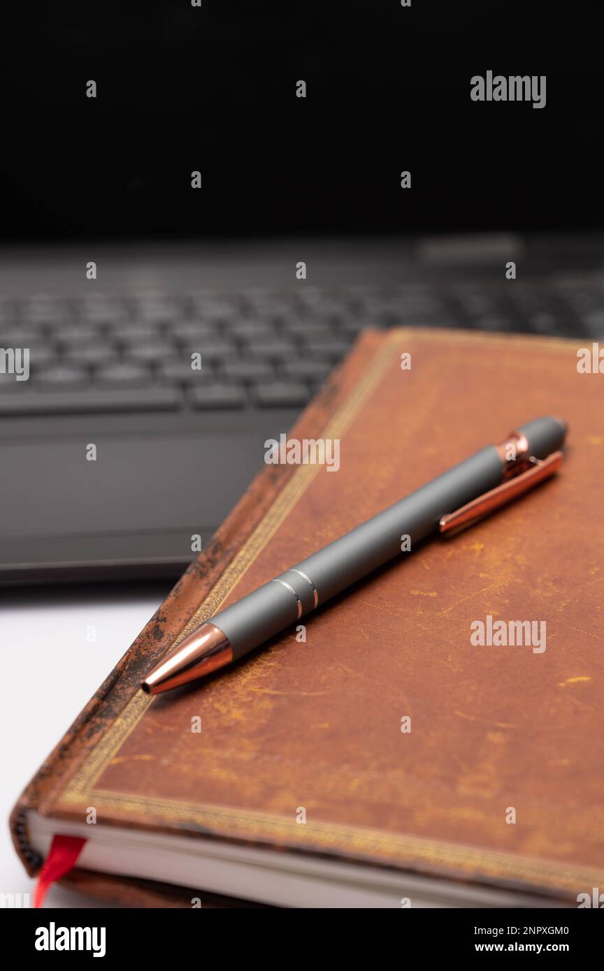 A vintage notebook with character with a pen on a black desktop with a ...