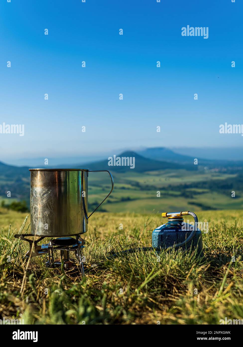 Cooking brewing coffee tee on a gas stove on a mountain with beautiful ...