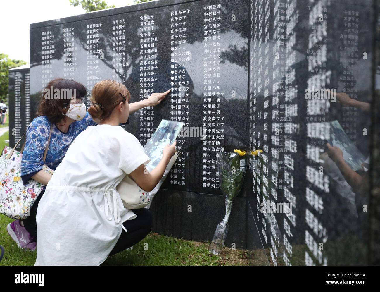 People mourn their family membersin front of Heiwa-no-Ishiji on which ...