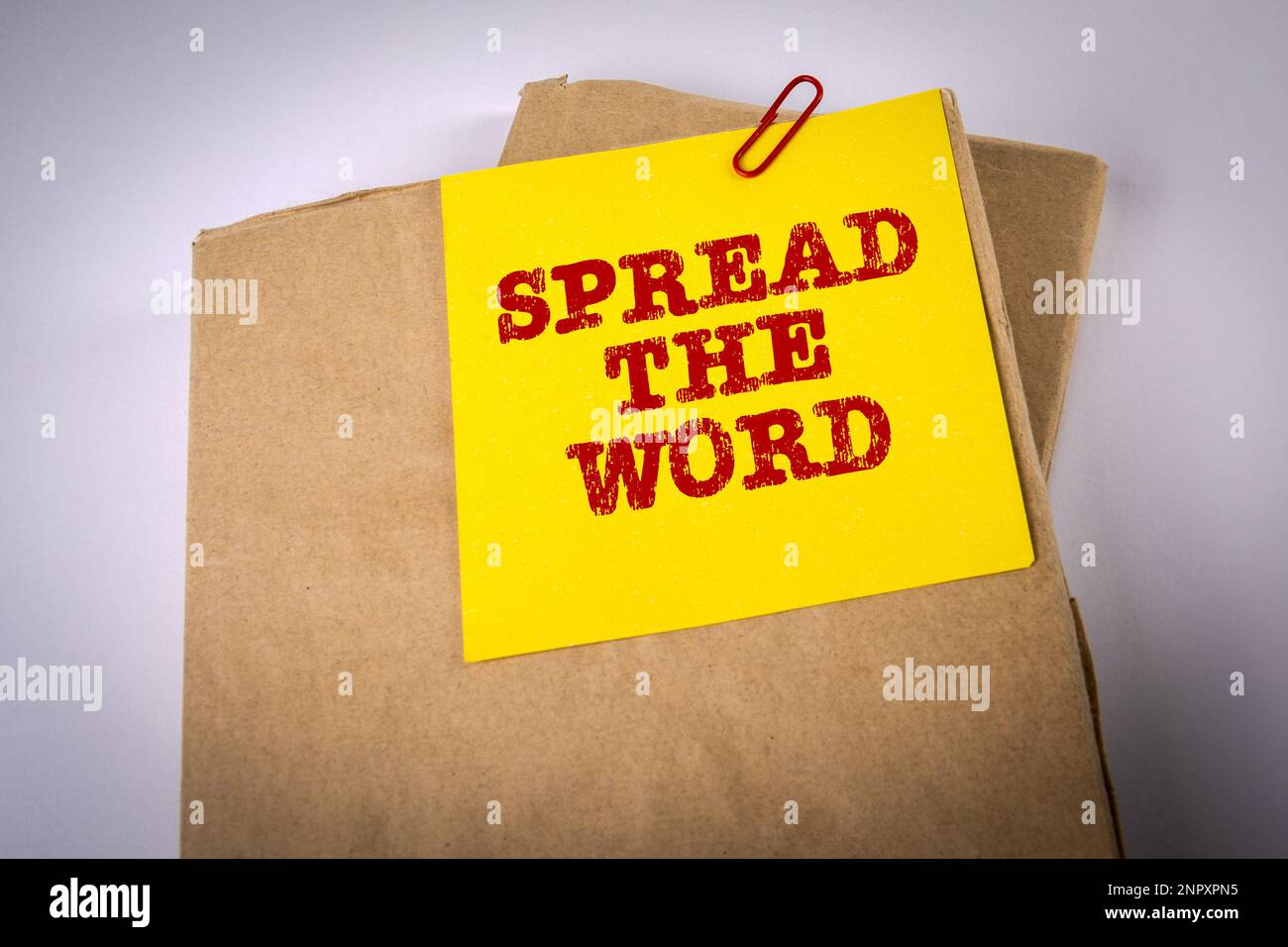 Spread the word. Textbooks with a yellow note sheet Stock Photo - Alamy