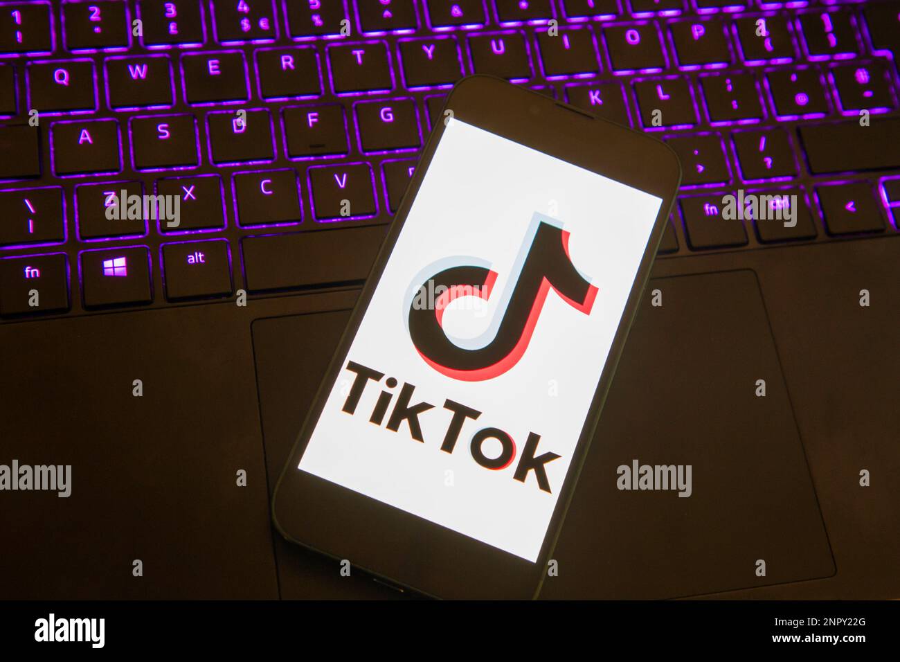 iPhone with Tik Tok app loading sitting on an illuminated laptop Stock ...