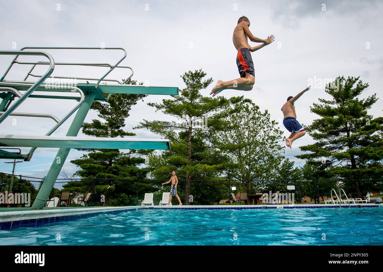 Kristian Beck, 14, center, and Wyatt Mills, 13, right, dive into the ...