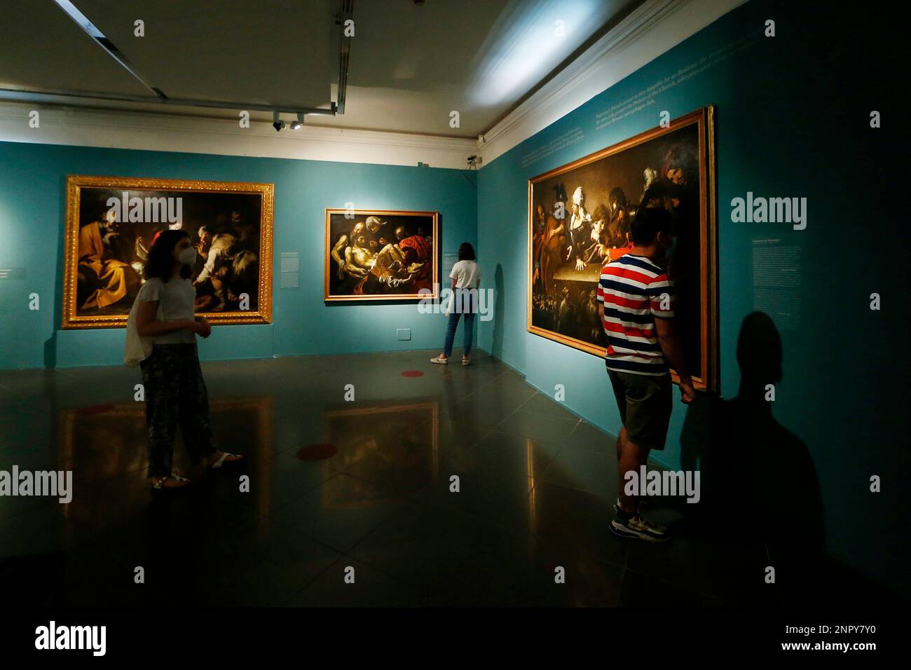 Visitors admire paintings part of the exhibition The Time of Caravaggio ...