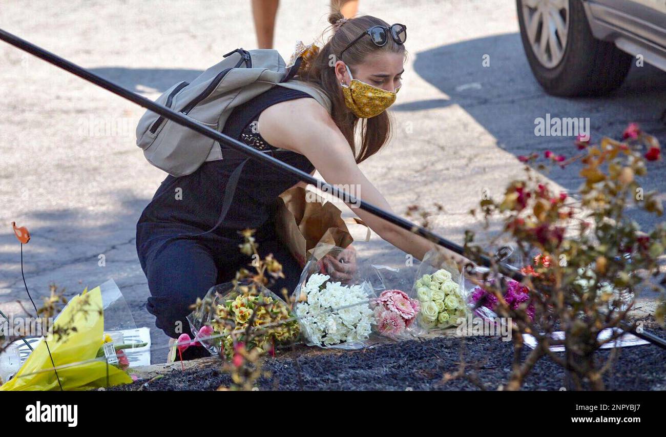 Natalie Olsen lays flowers at the memorial in the Wendy's parking lot ...