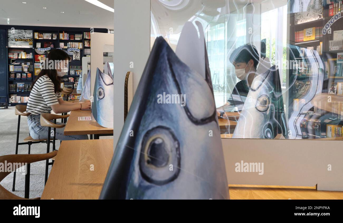 Bluefin tuna-shaped mask covers are laid on a desk to maintain a social ...