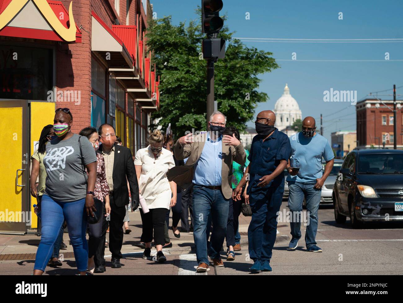 Minnesota Gov. Tim Walz, center, takes a walking tour of some of the ...