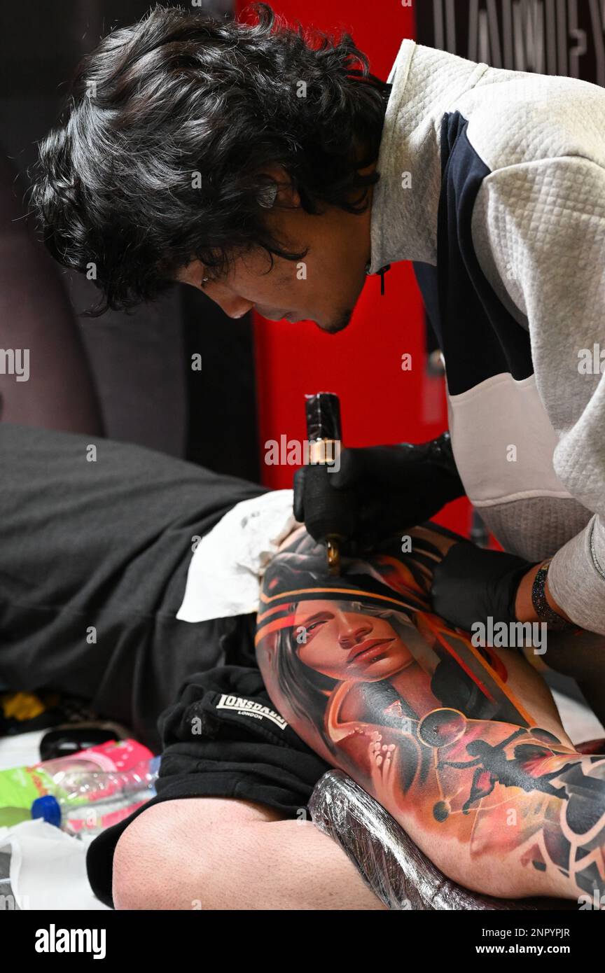 Brighton UK. 26th February 2023. Tattoo artist AMIR LAMEYRA works on Hayden Clement. The 14th ...