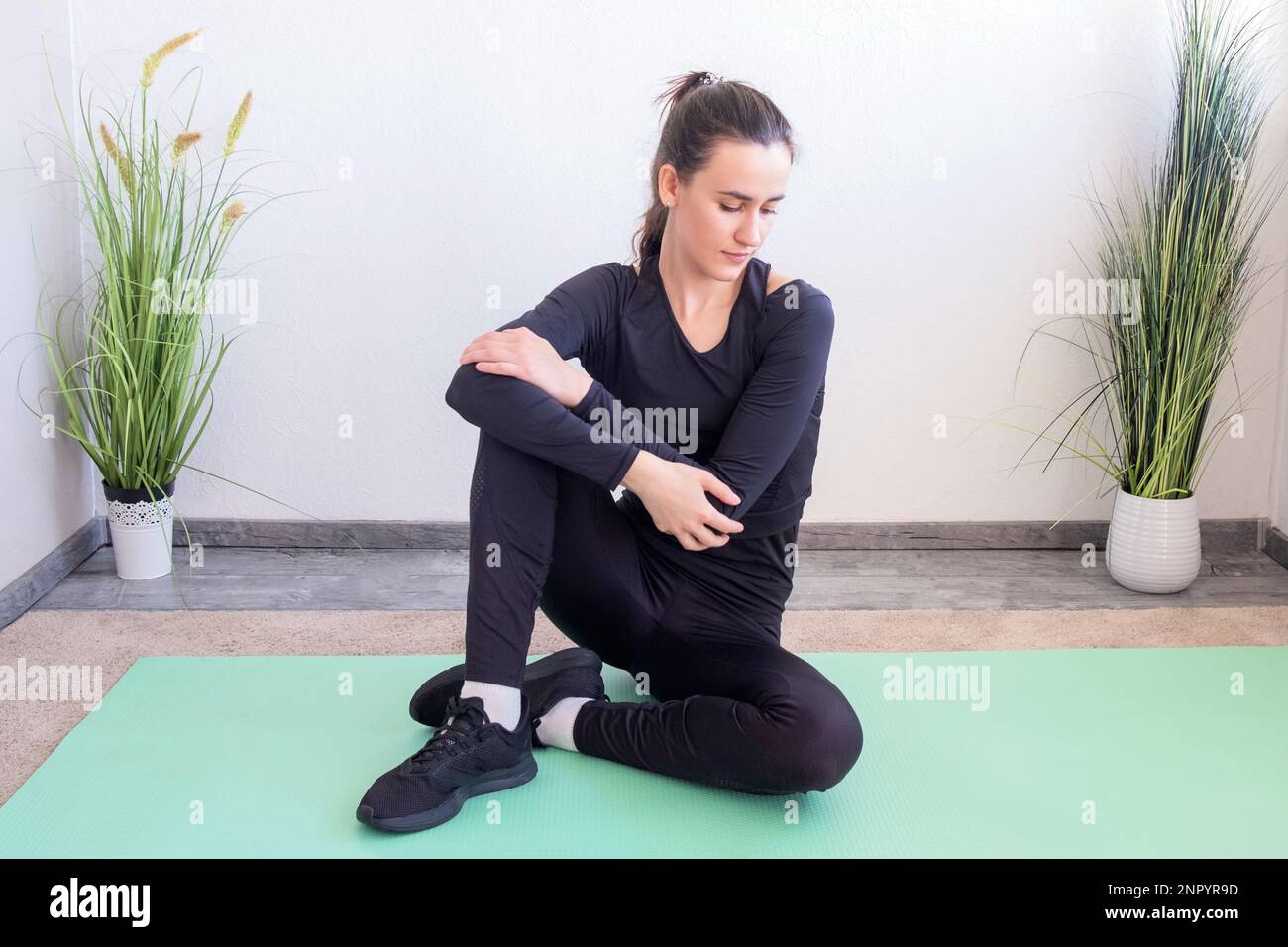 Beautiful young woman dressed in a black sports uniform after exercise ...