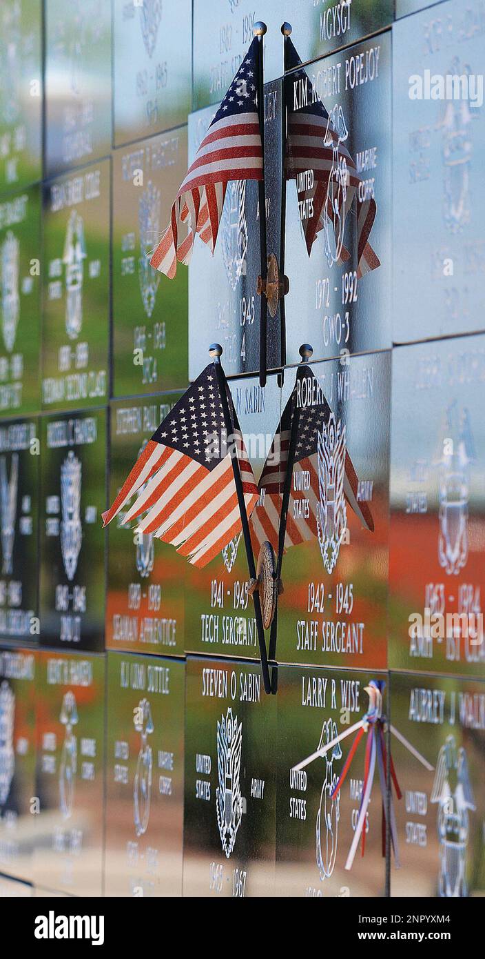 Two weathered American flags and a small red, white and blue ribbon ...