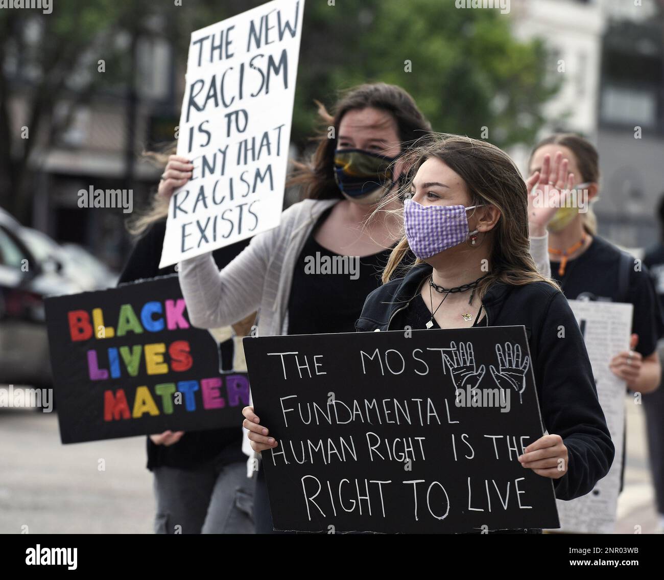 Protesters hold signs in Naperville, Ill., Monday, June 1, 2020 ...