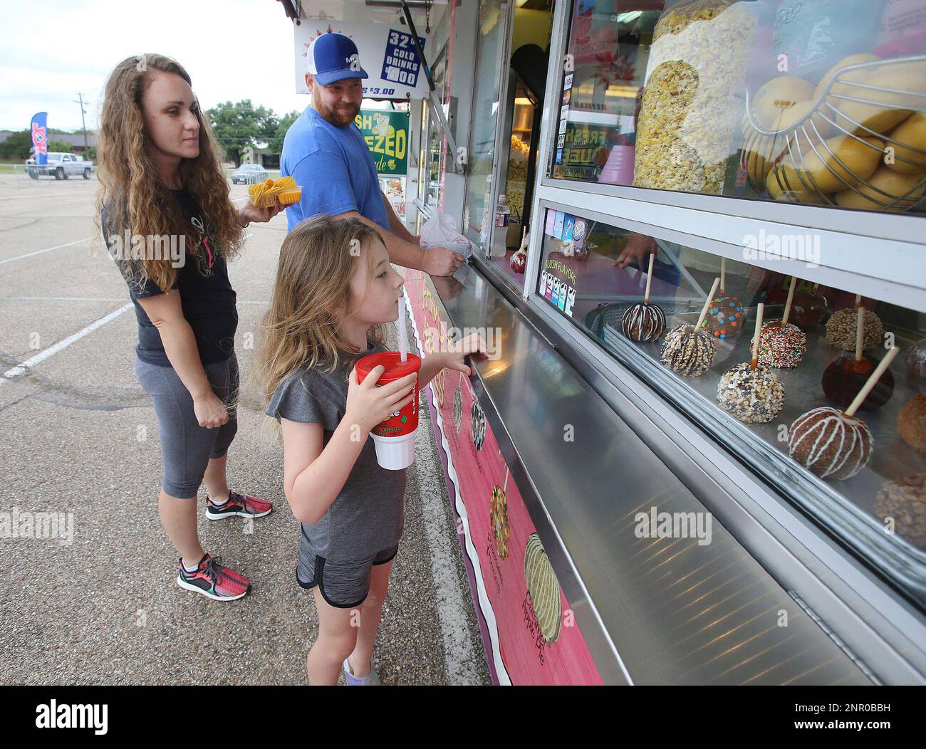 Laney Vanek, 7, looks over candy apples as she and her father Adam ...
