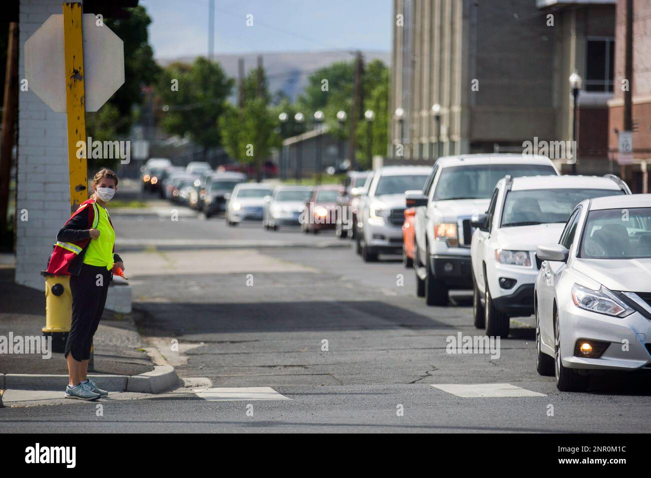 Sister Brown directs traffic as a line of cars form for a drive-up food ...
