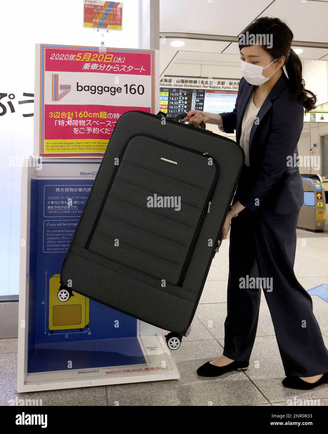 A woman demonstrates to bring her large-size baggage to check with ...