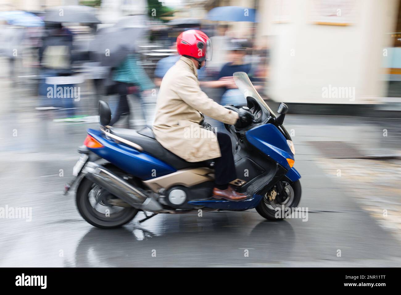 picture in intentional motion blur of a man with a scooter driving in ...