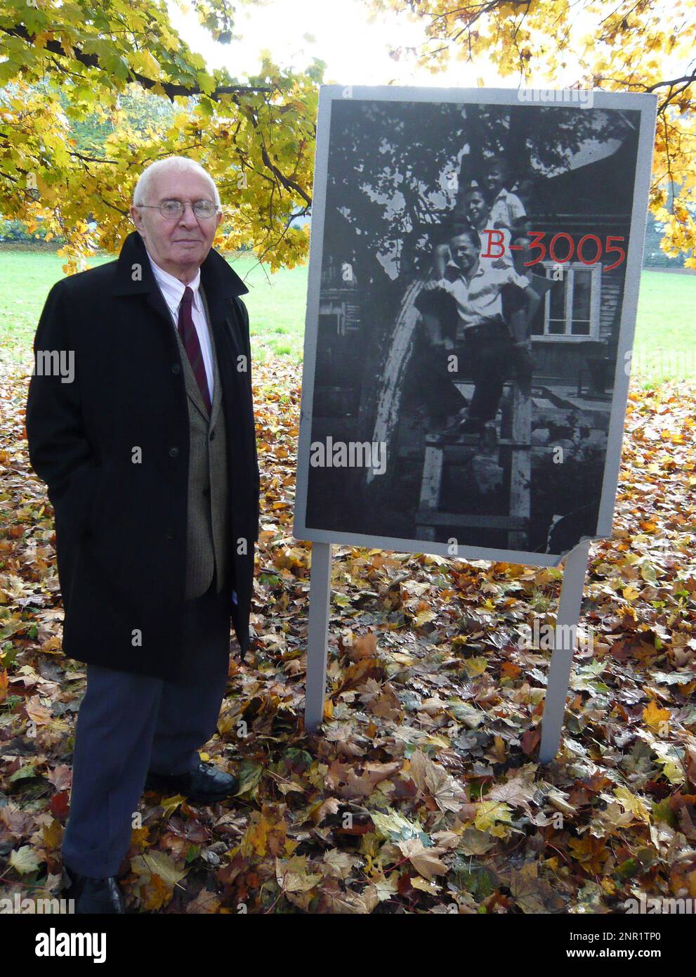 Alexander Feingold stands next to a memorial photo honouring his legacy ...