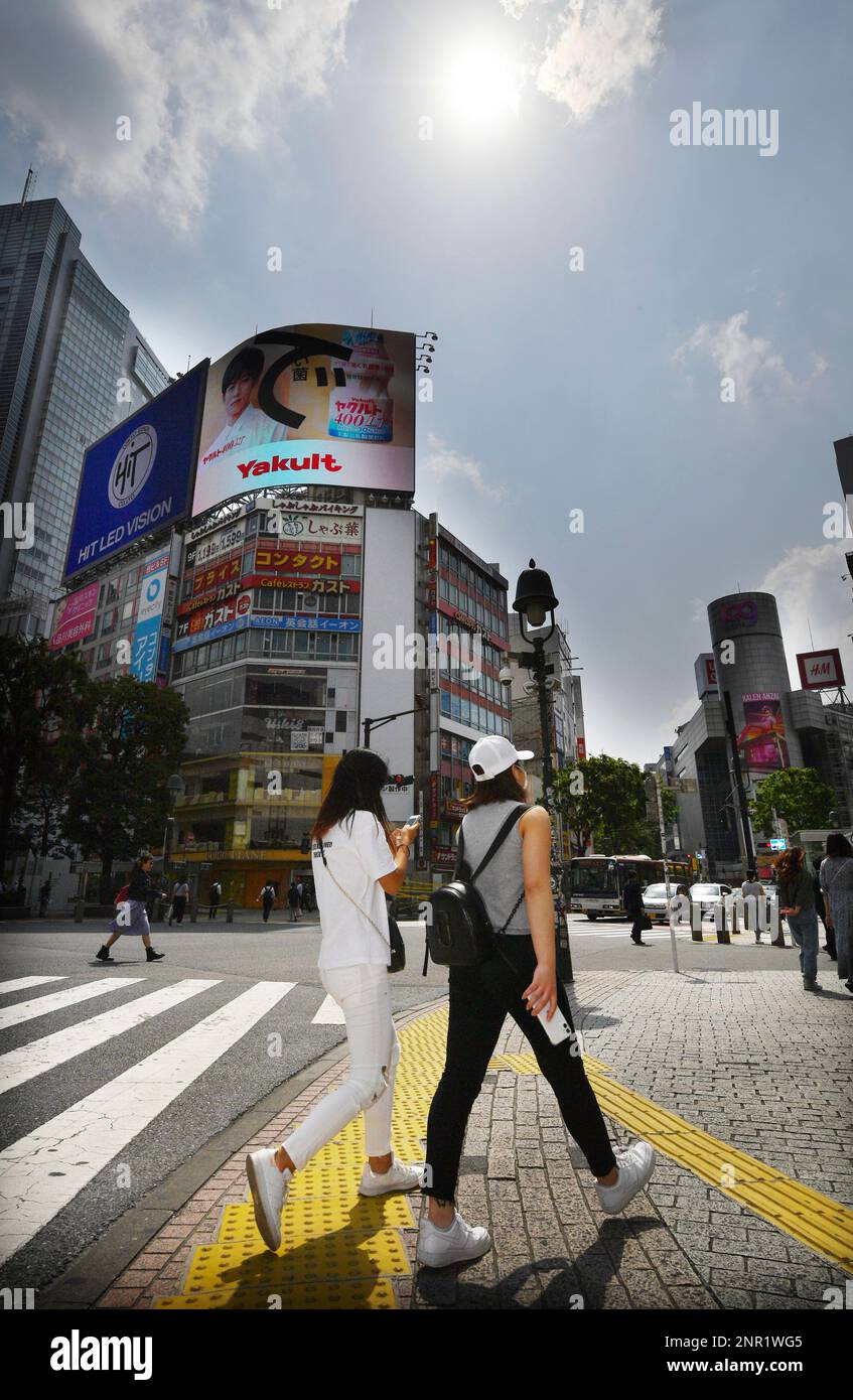 Women wearing a face mask walk during a hot day in Shibuya Ward, Tokyo ...