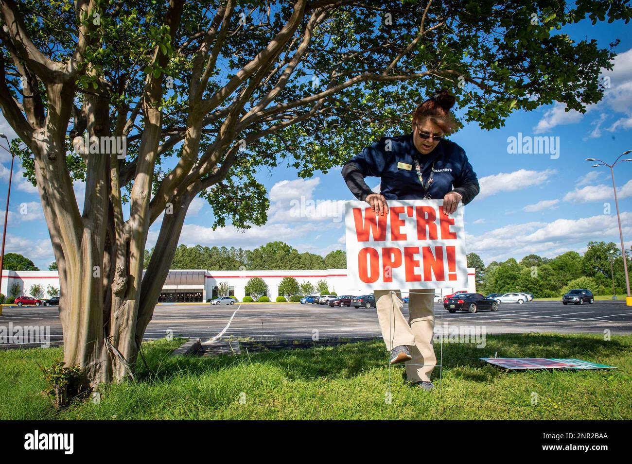 Viki Milliken puts out open signs at Martin's Family Clothing as state ...