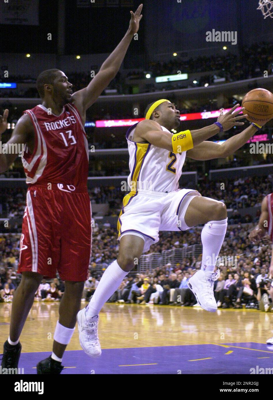 Derek Fisher of the Los Angeles Lakers drives past Kelvin Cato of the ...