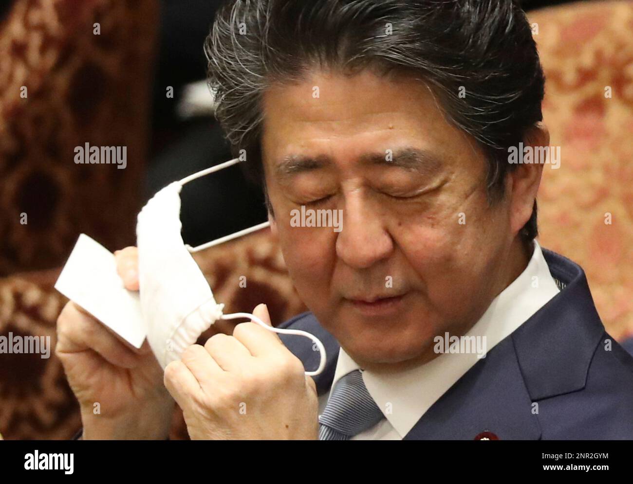 Prime Minister Shinzo Abe. taking off a face mask, answers a question ...