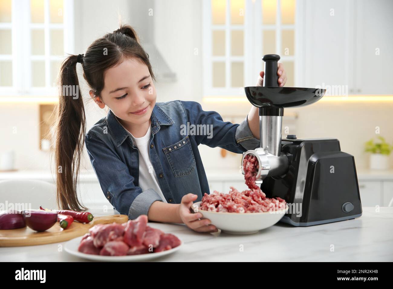 Little girl using modern meat grinder in kitchen Stock Photo - Alamy