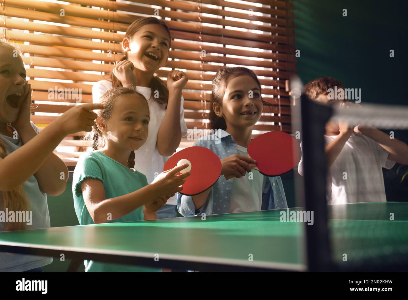 Cute happy children playing ping pong indoors Stock Photo - Alamy