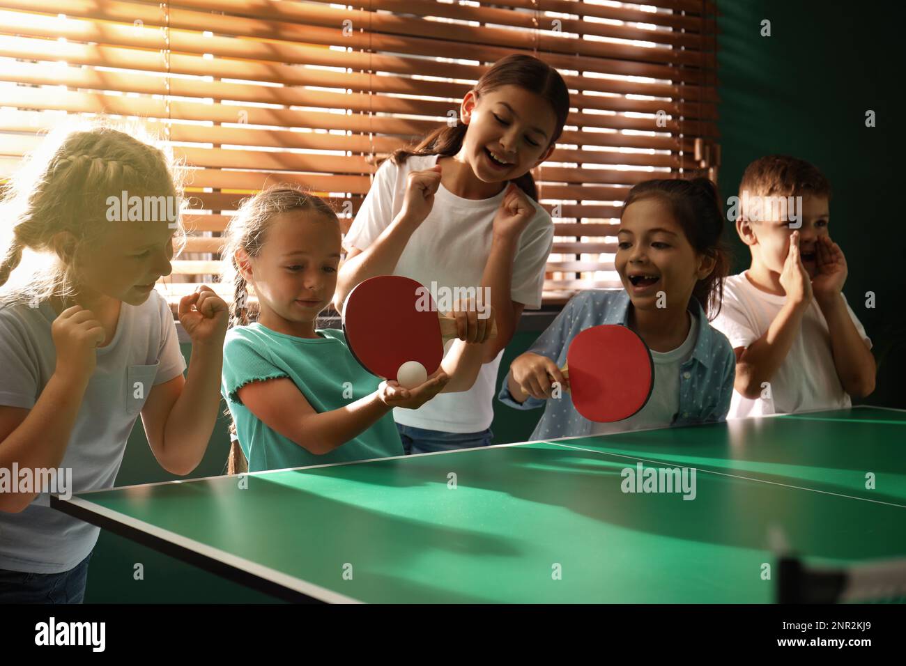 Cute happy children playing ping pong indoors Stock Photo - Alamy