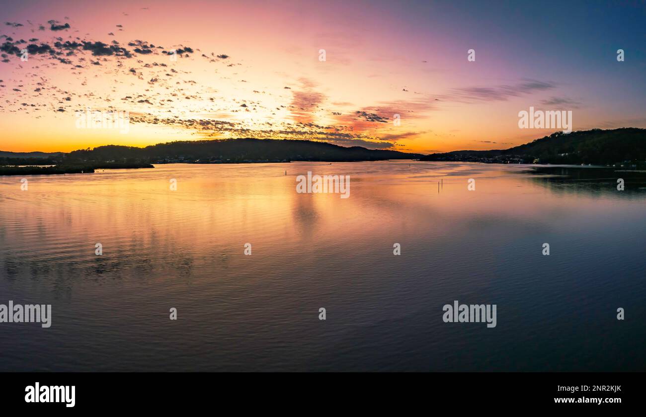 Aerial sunrise over the bay with altocumulus clouds painting the sky at ...