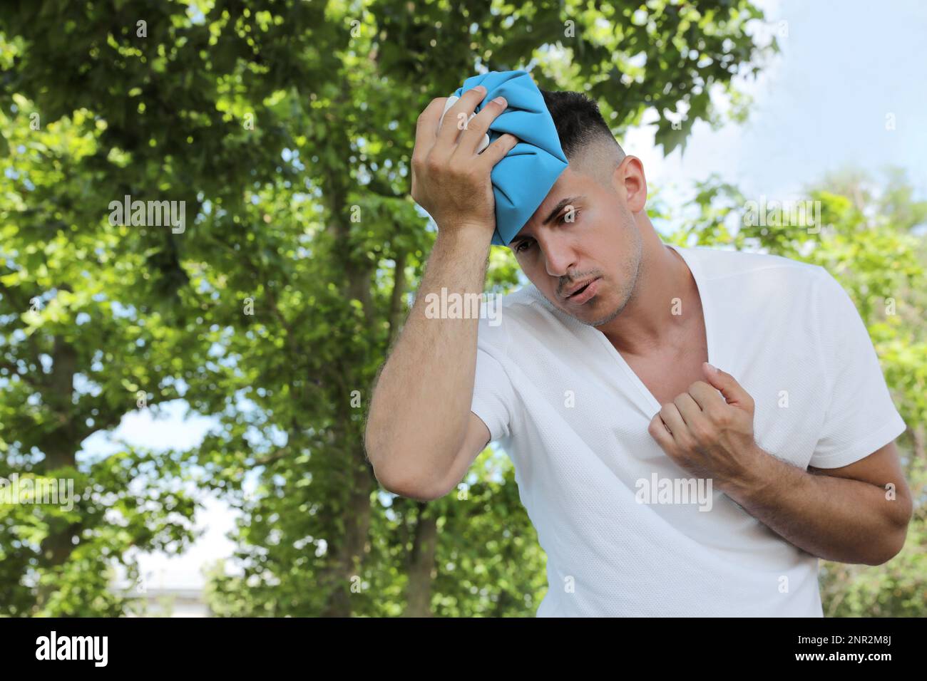 Man with cold pack suffering from heat stroke outdoors Stock Photo - Alamy