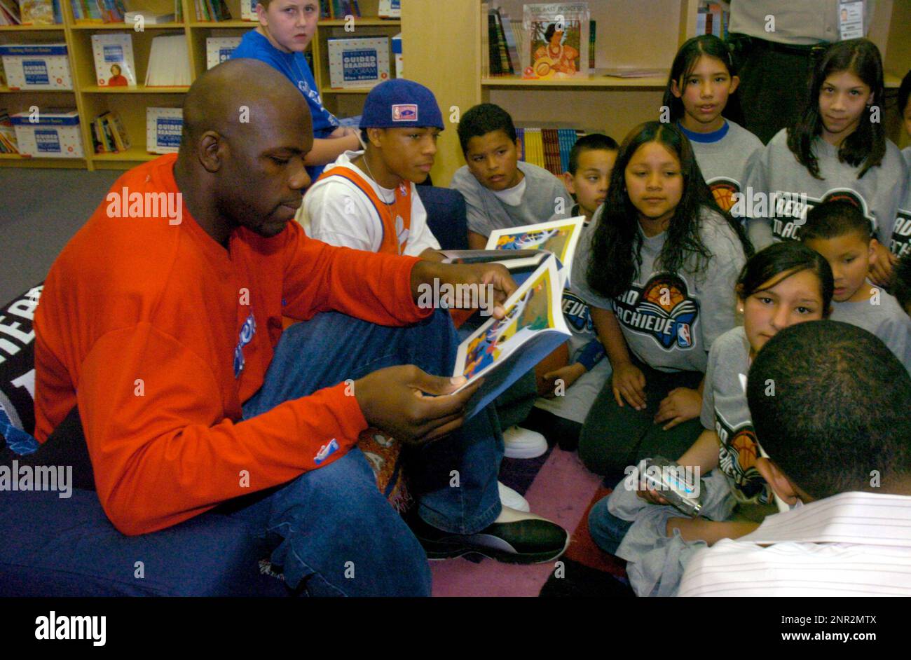 Josh Moore of the Los Angeles Clippers (left) and Bow Wow read books to ...