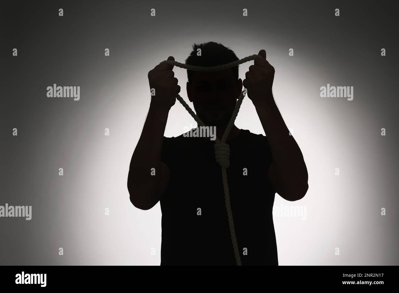Silhouette of man with rope noose on light background Stock Photo - Alamy