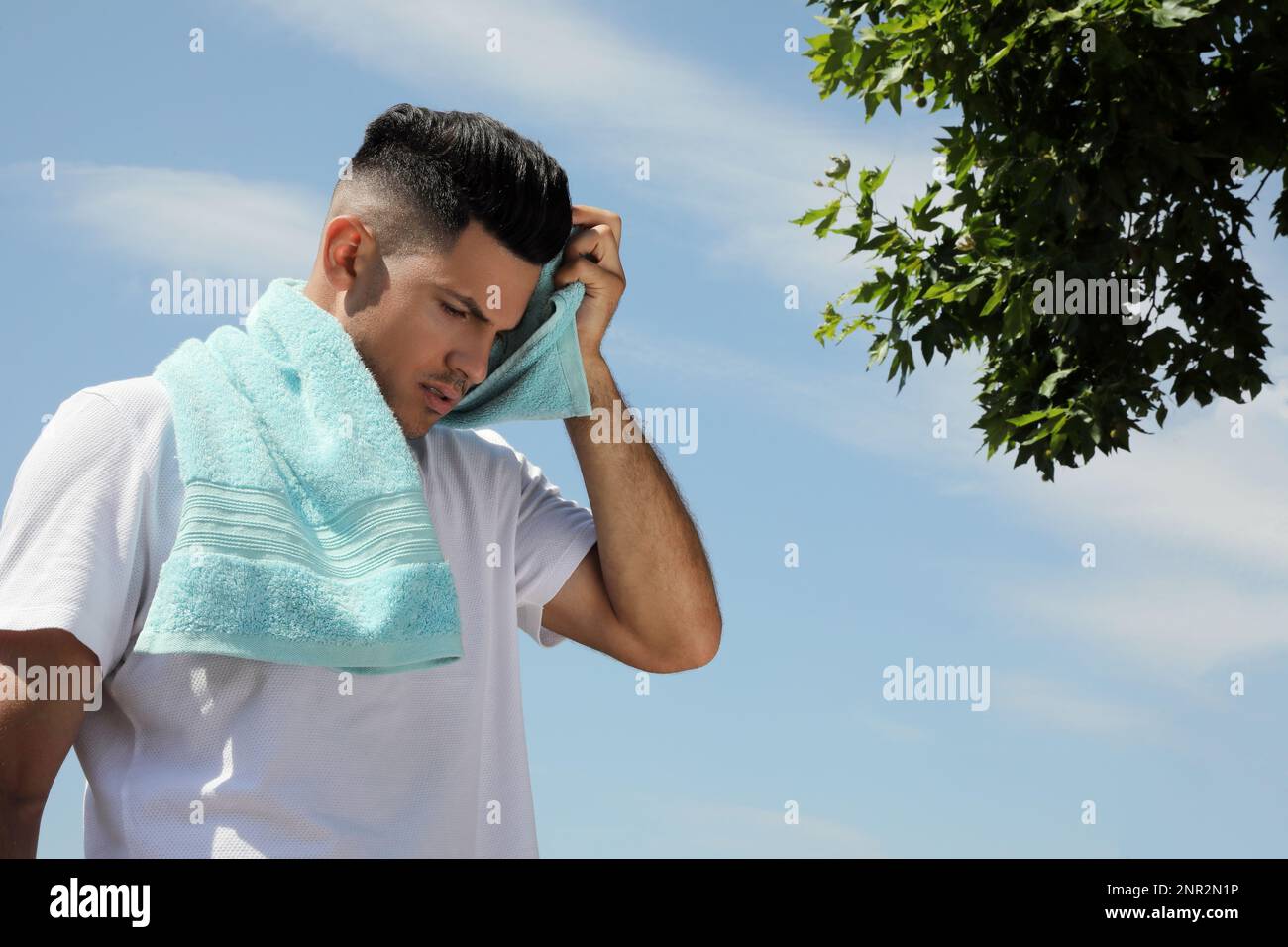 Man with towel suffering from heat stroke outdoors Stock Photo - Alamy