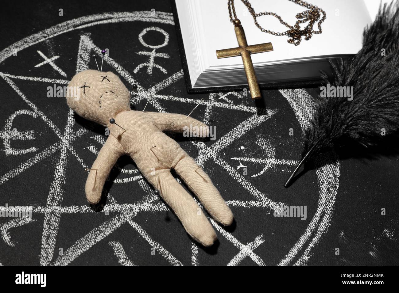 Ceremonial items and voodoo doll in ritual circle drawn on black table ...