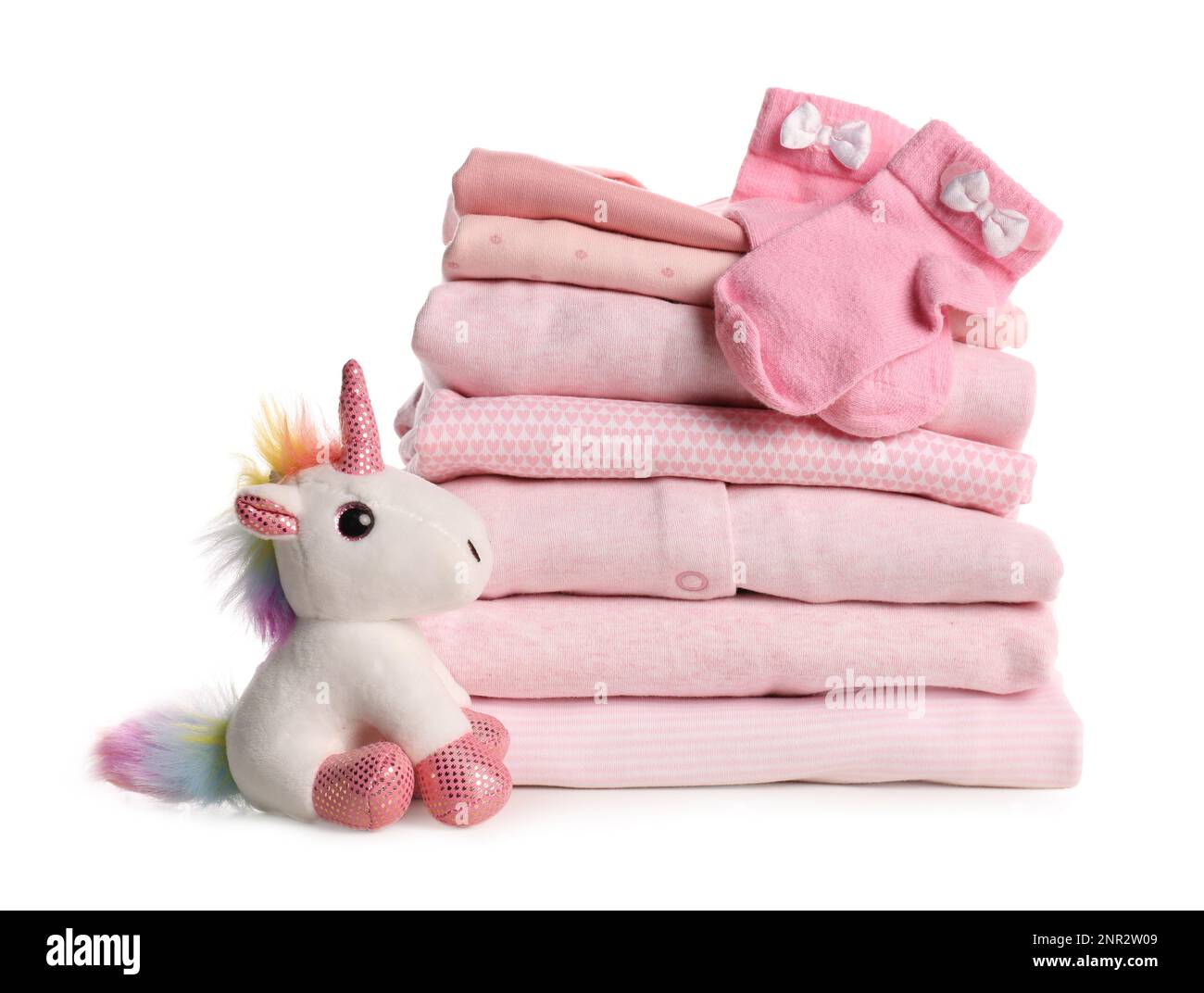 Stack of baby girl's clothes, socks and toy unicorn on white background ...