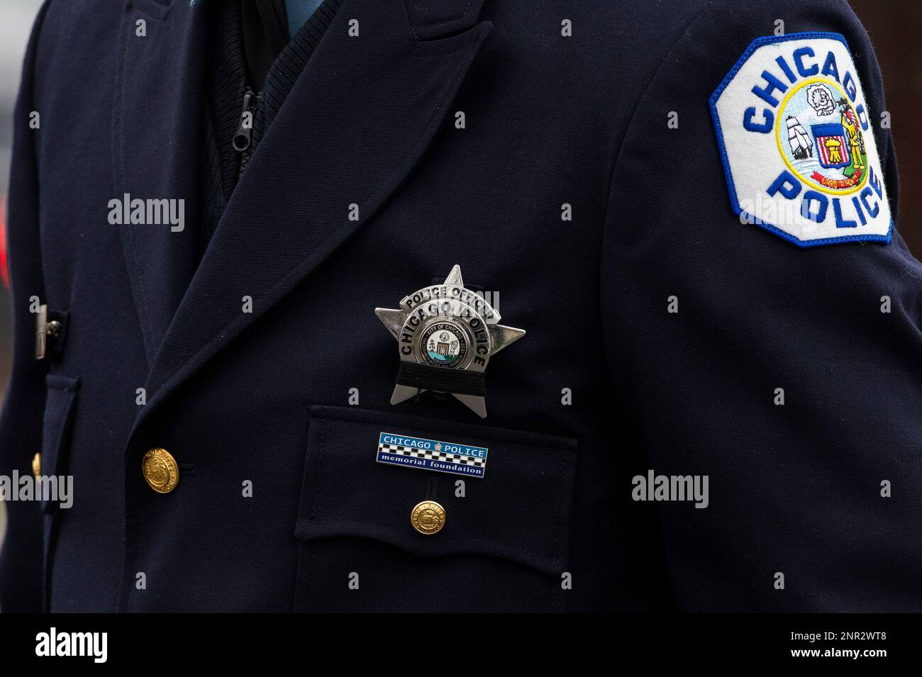 A Chicago police officer wears a black ribbon on his badge, at the ...