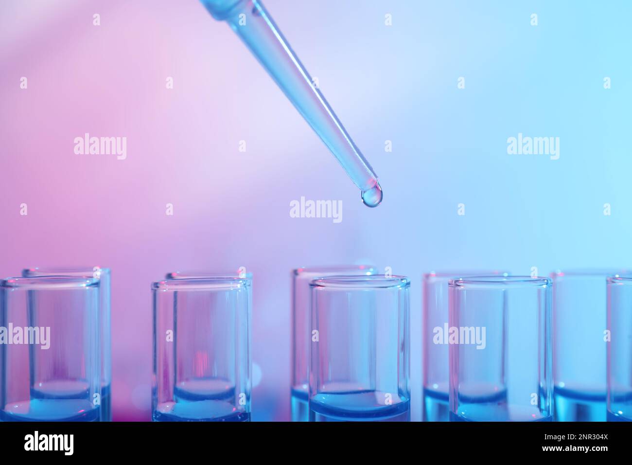 Dripping reagent into test tube with blue liquid, closeup. Laboratory ...
