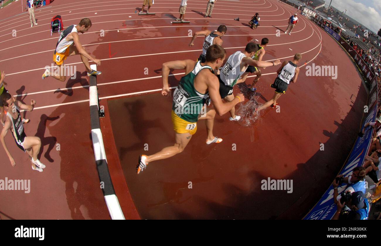 Runner negotiate the water jump in the steeplechase in the USA Track ...