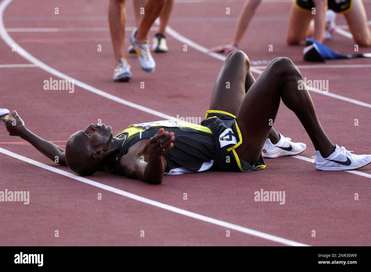 Bernard Lagat lies on the track in exhaustion after winning the 5,000 ...