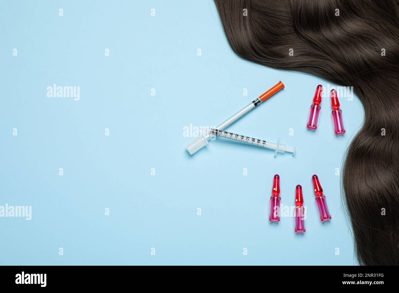 Hair lock, ampoules and syringes on light blue background, flat lay ...