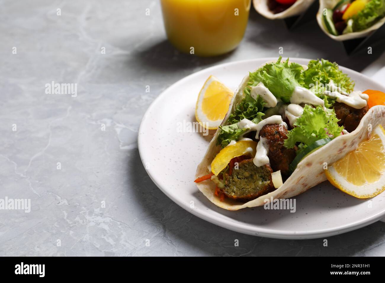 Delicious fresh vegan taco served on light grey marble table, space for ...