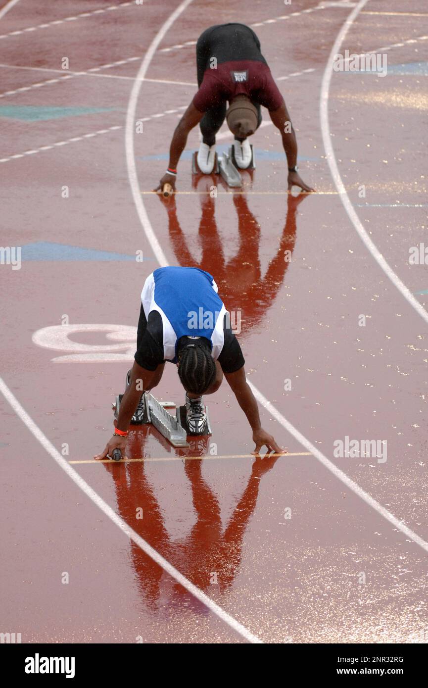 Runners take their marks in the starting blocks in the college 4 x 100 ...