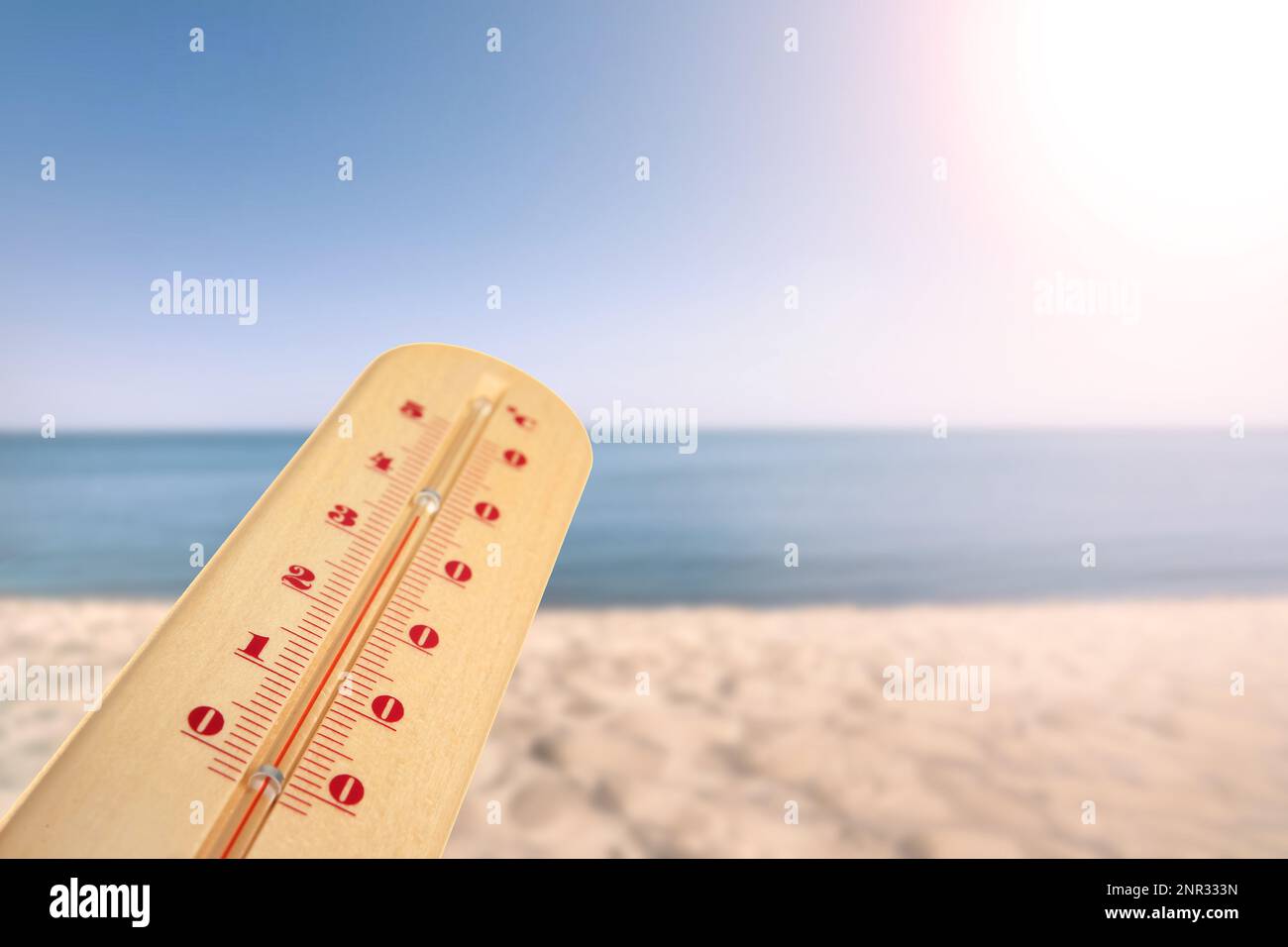 Closeup view of weather thermometer and beautiful seashore on ...