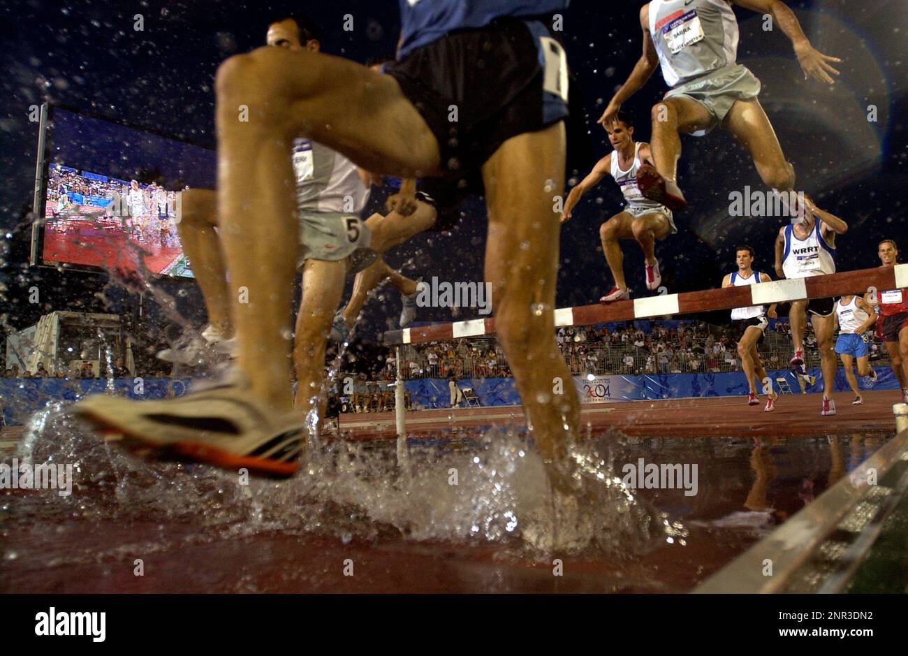 Competitors in the men's steeplechase negotiate the water jump in the U ...