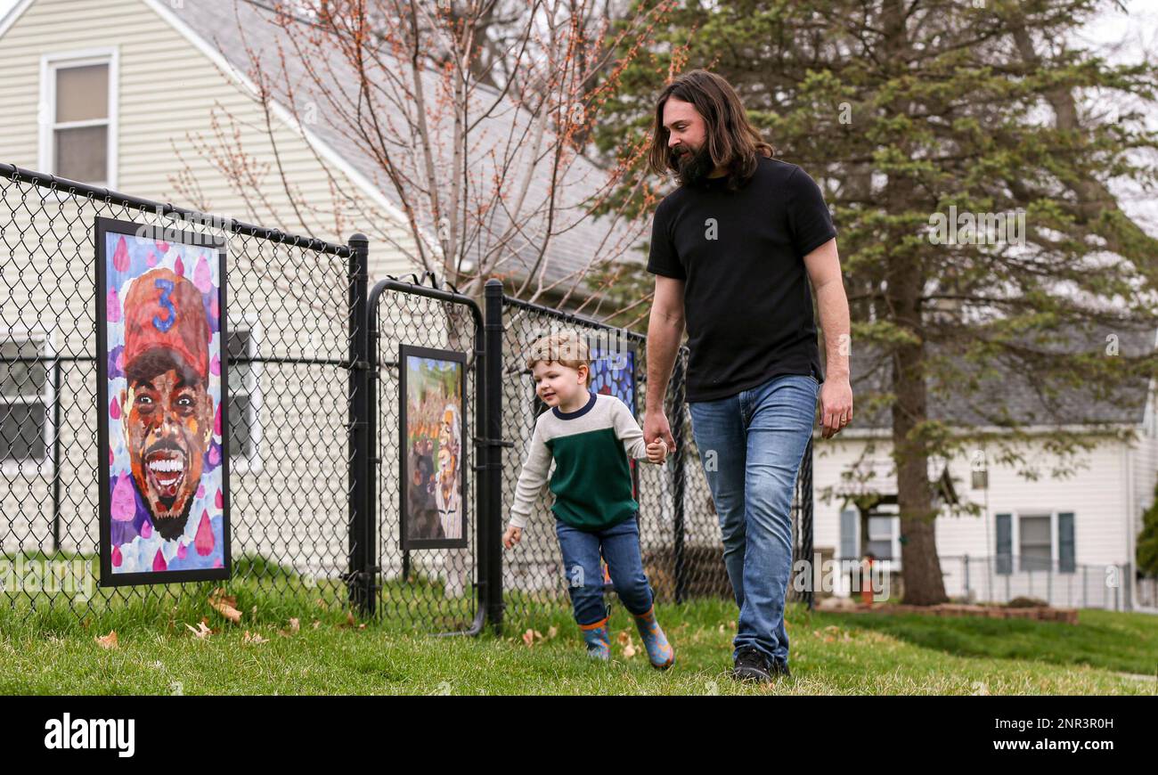 Artist Shane McCallister walks with his son, Smith, 4, past his artwork ...