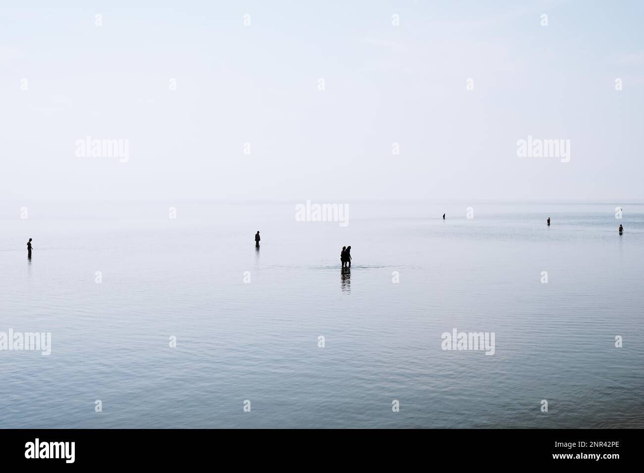 group of people walking and wading through shallow water at German ...
