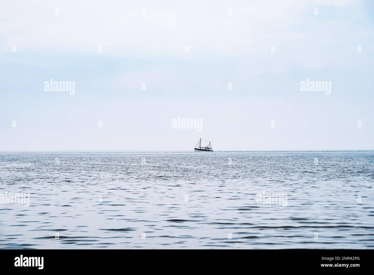 distant shrimp boat at the horizon, north sea in Germany Stock Photo ...